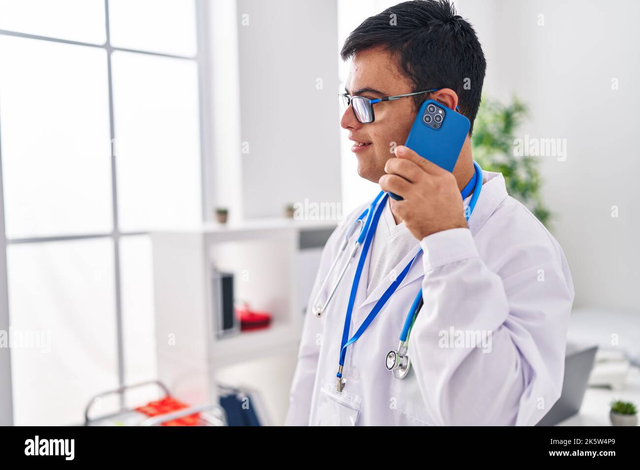 Down syndrome man wearing doctor uniform talking on the smartphone at ...