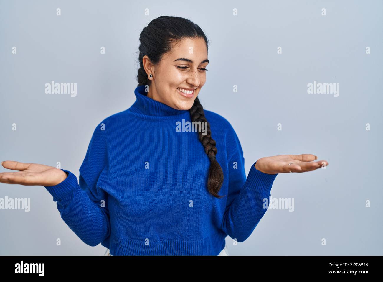 Young hispanic woman standing over isolated background smiling showing ...