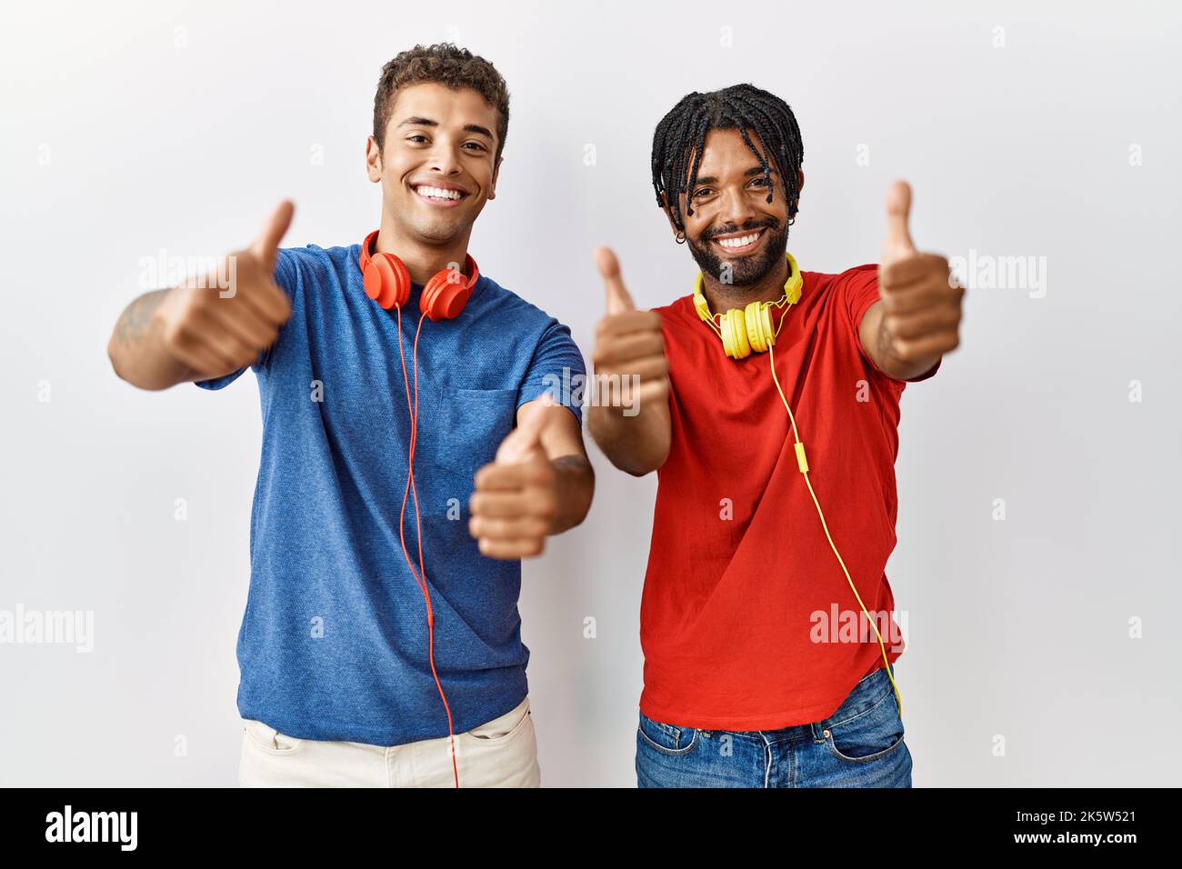 Young hispanic brothers standing over isolated background wearing ...