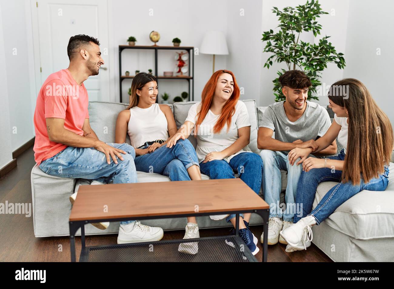 Group of young friends smiling happy sitting on the sofa at home Stock ...