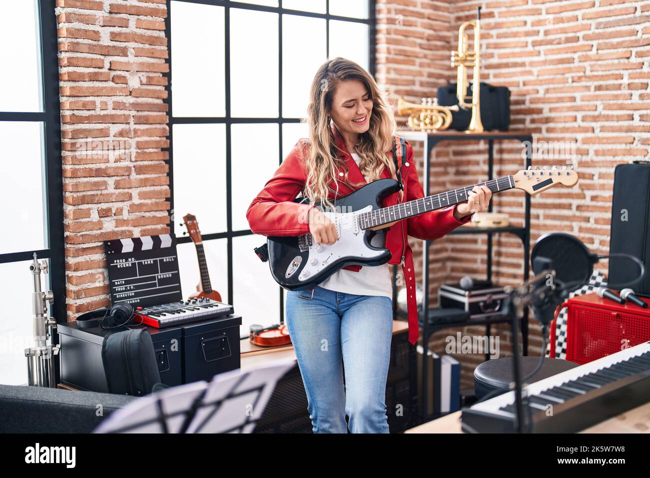 Young woman musician playing electrical guitar at music studio Stock ...