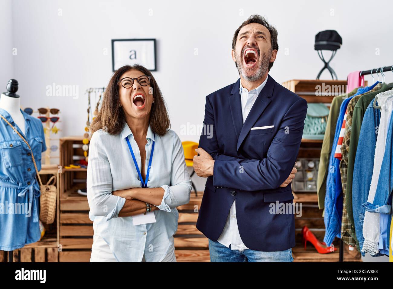 Two hispanic people working as manager at retail boutique angry and mad ...