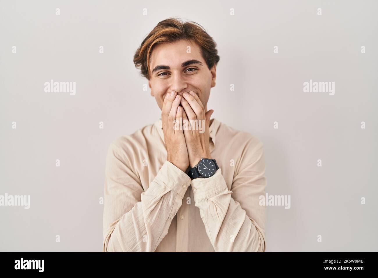 Young man standing over isolated background laughing and embarrassed ...