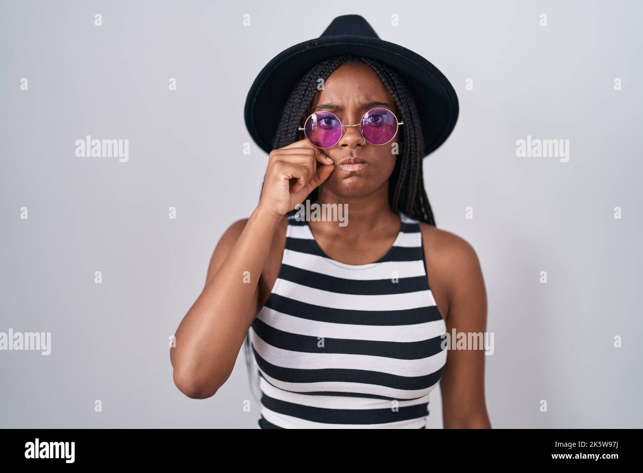 Young african american with braids wearing hat and sunglasses mouth and ...