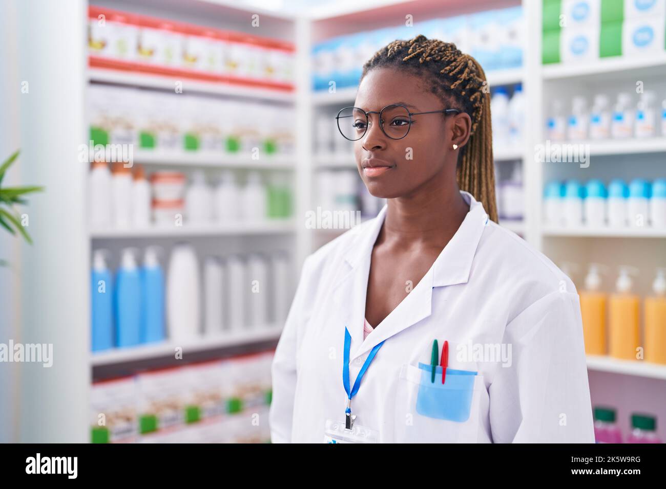 African american woman pharmacist standing with serious expression at ...