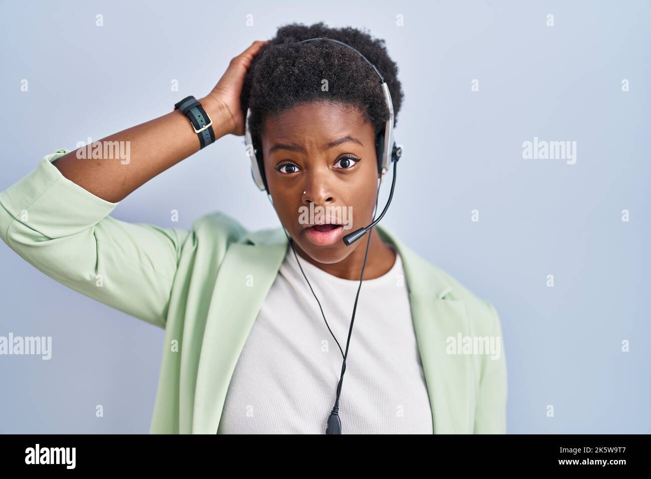 African american woman wearing call center agent headset crazy and ...