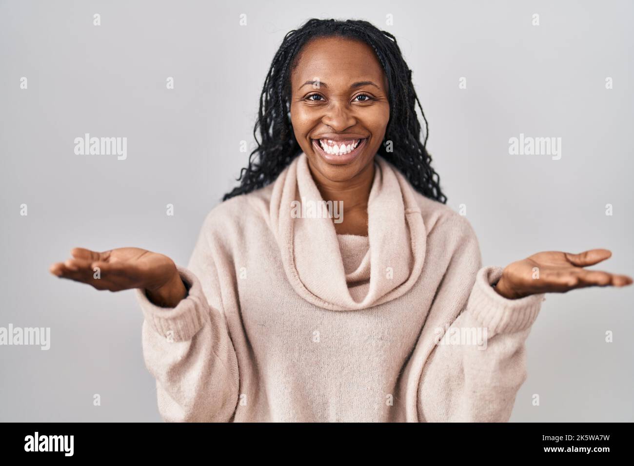 African woman standing over white background smiling cheerful offering ...