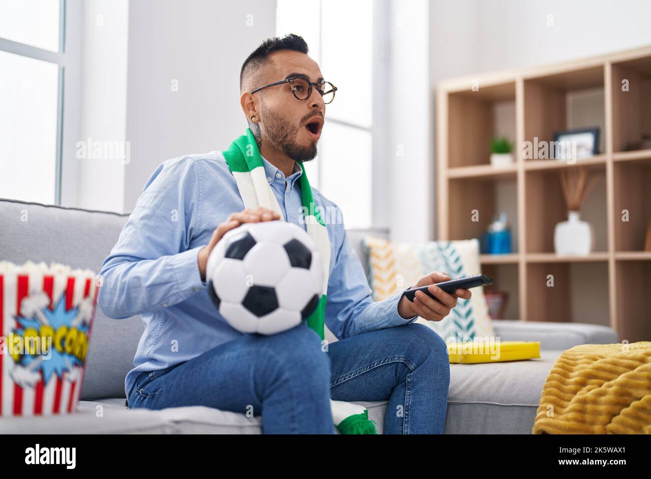 Young hispanic man football hooligan holding ball supporting team ...