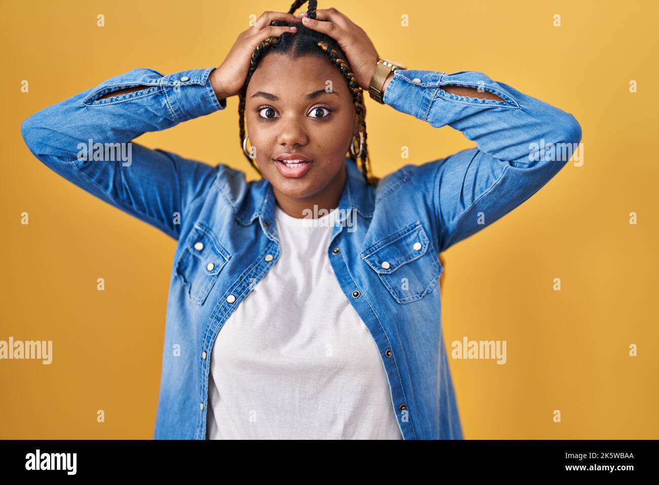 African american woman with braids standing over yellow background ...