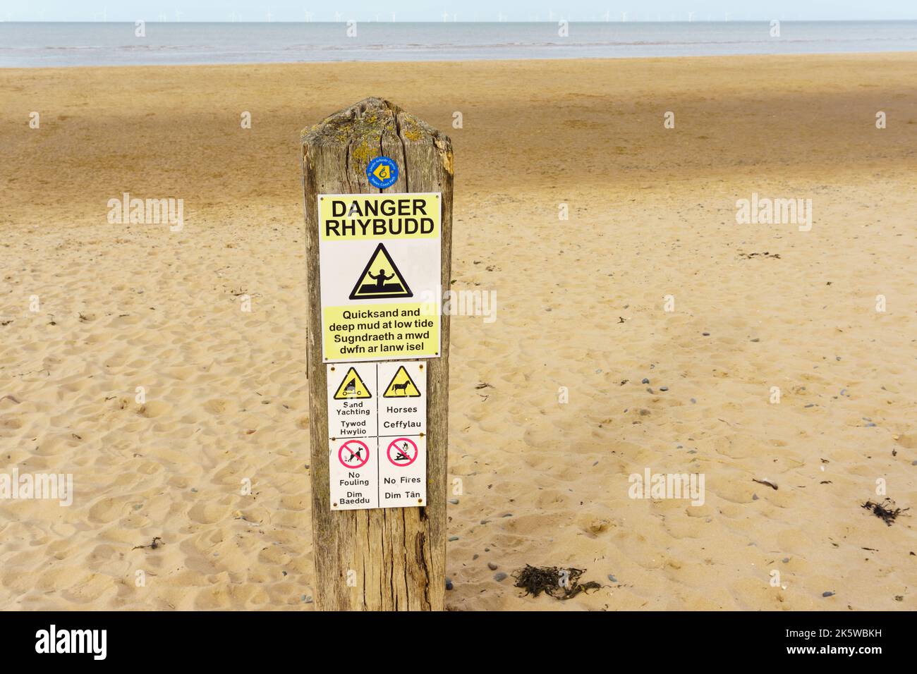Warning sign in English and Welsh languages on a beach advising bathers ...