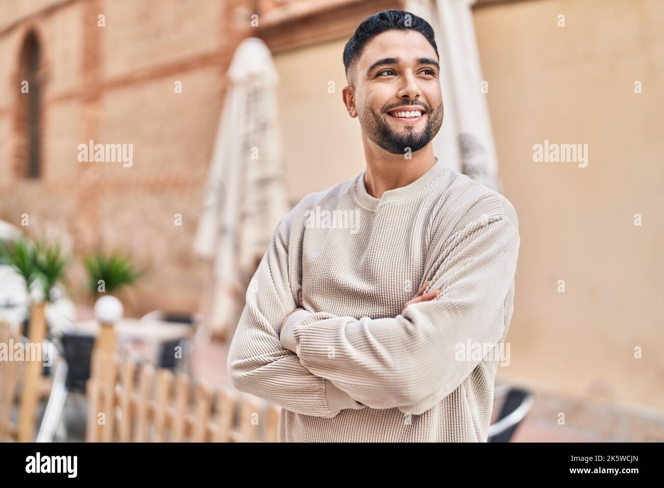 Young arab man smiling confident standing with arms crossed gesture at ...