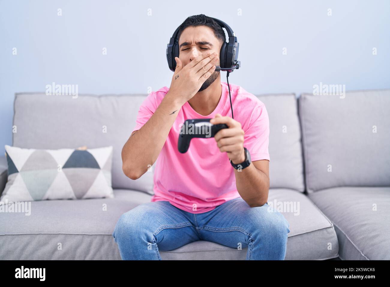 Hispanic young man playing video game holding controller sitting on the ...