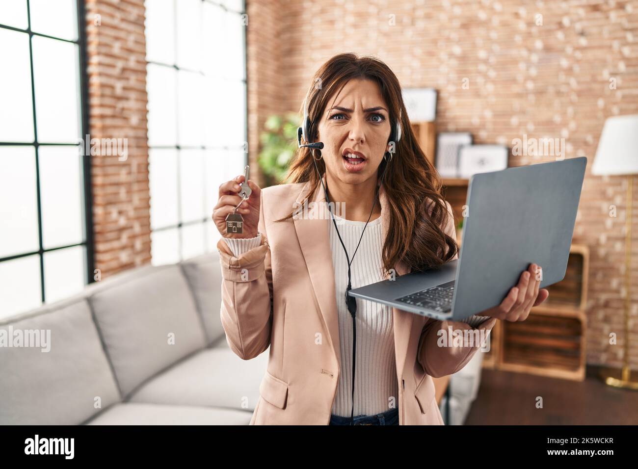 Young brunette woman working as real state agent holding keys of new ...