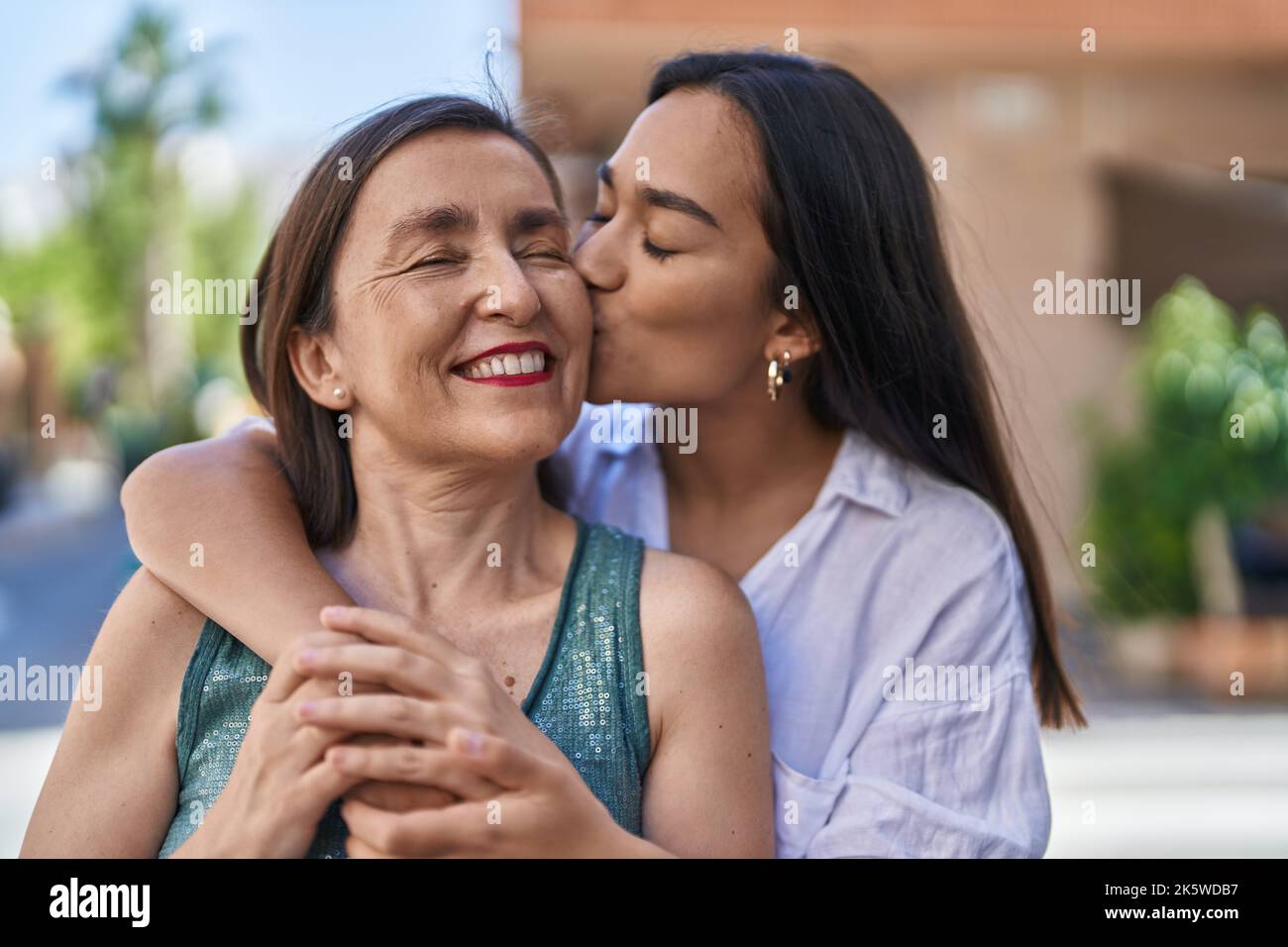 Two women mother and daughter hugging each other kissing at street Stock Photo - Alamy