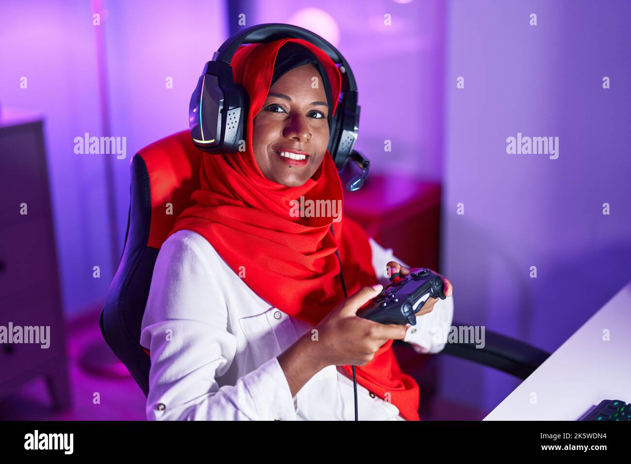 Young beautiful woman streamer playing video game using joystick at ...