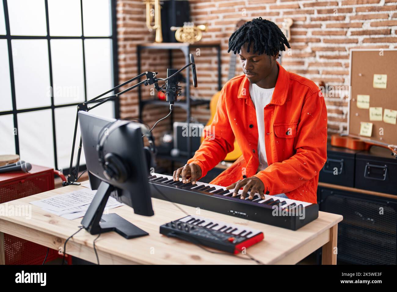 African american man musician playing piano keyboard at music studio ...