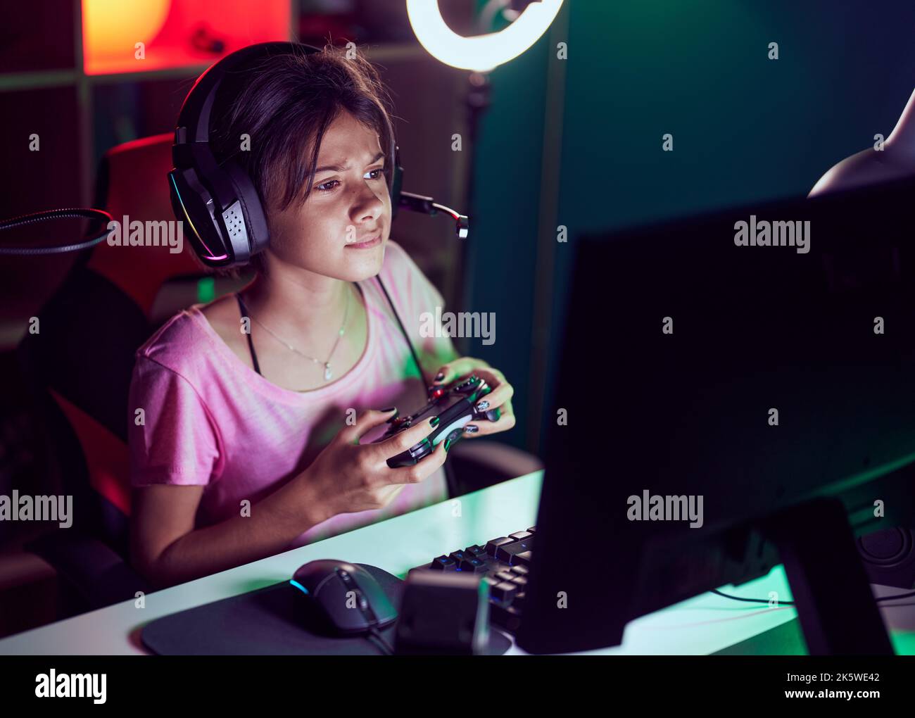 Adorable hispanic girl streamer playing video game using joystick at ...