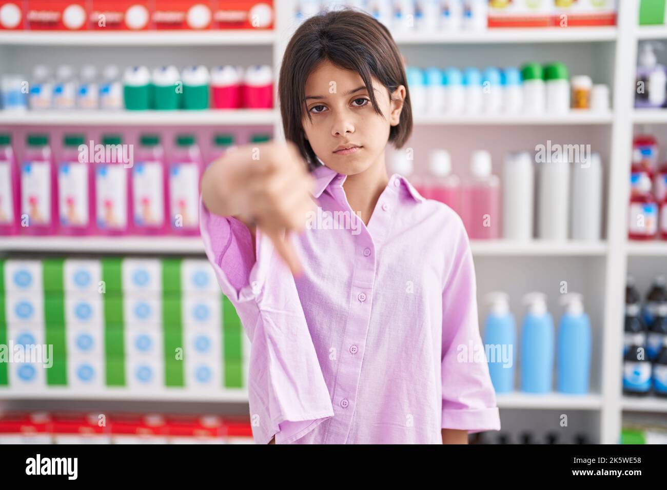 Young girl at pharmacy drugstore looking unhappy and angry showing ...