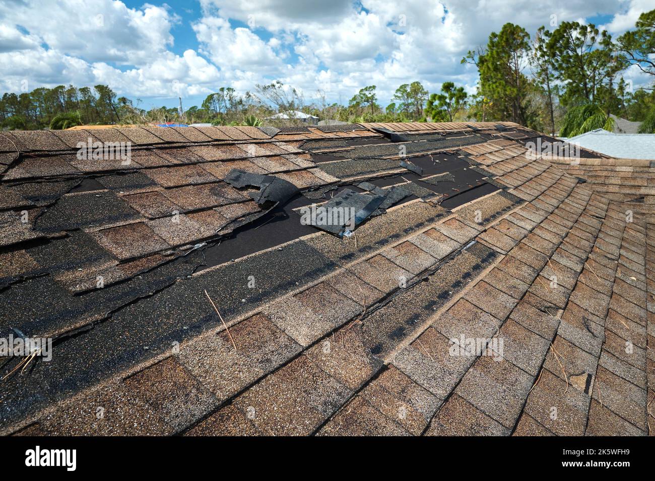 Damaged house roof with missing shingles after hurricane Ian in Florida ...