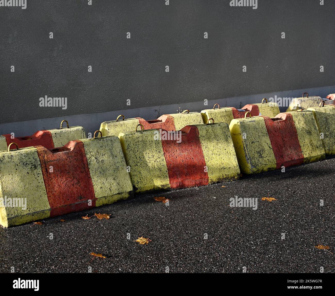 road concrete blocks and barriers on the asphalt near the wall Stock ...