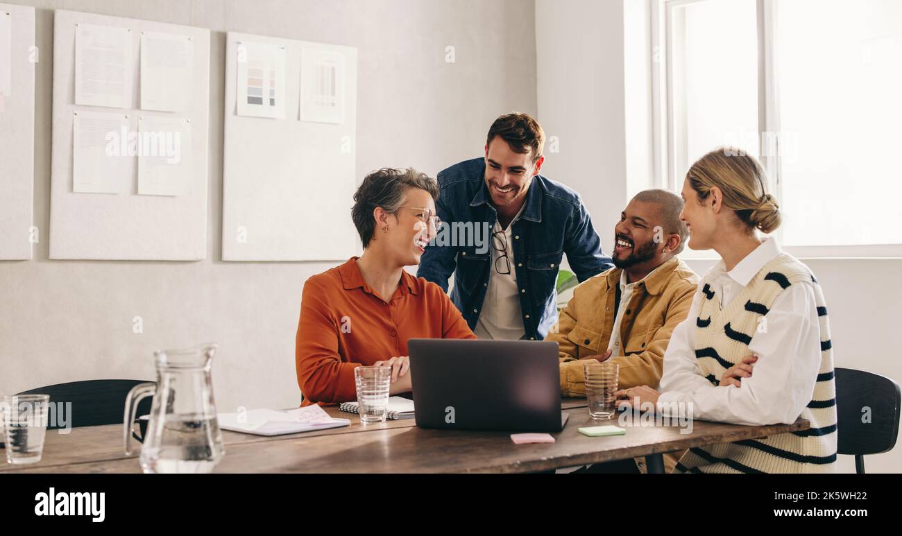 Cheerful designers smiling happily while having a meeting in an office ...