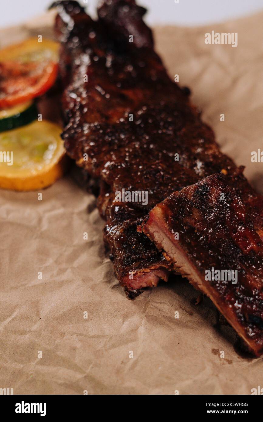 A vertical closeup of cooked ribs on a butcher paper Stock Photo - Alamy