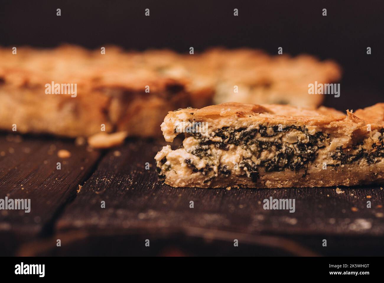 A closeup of a pie slice separated, with the whole pie in the ...