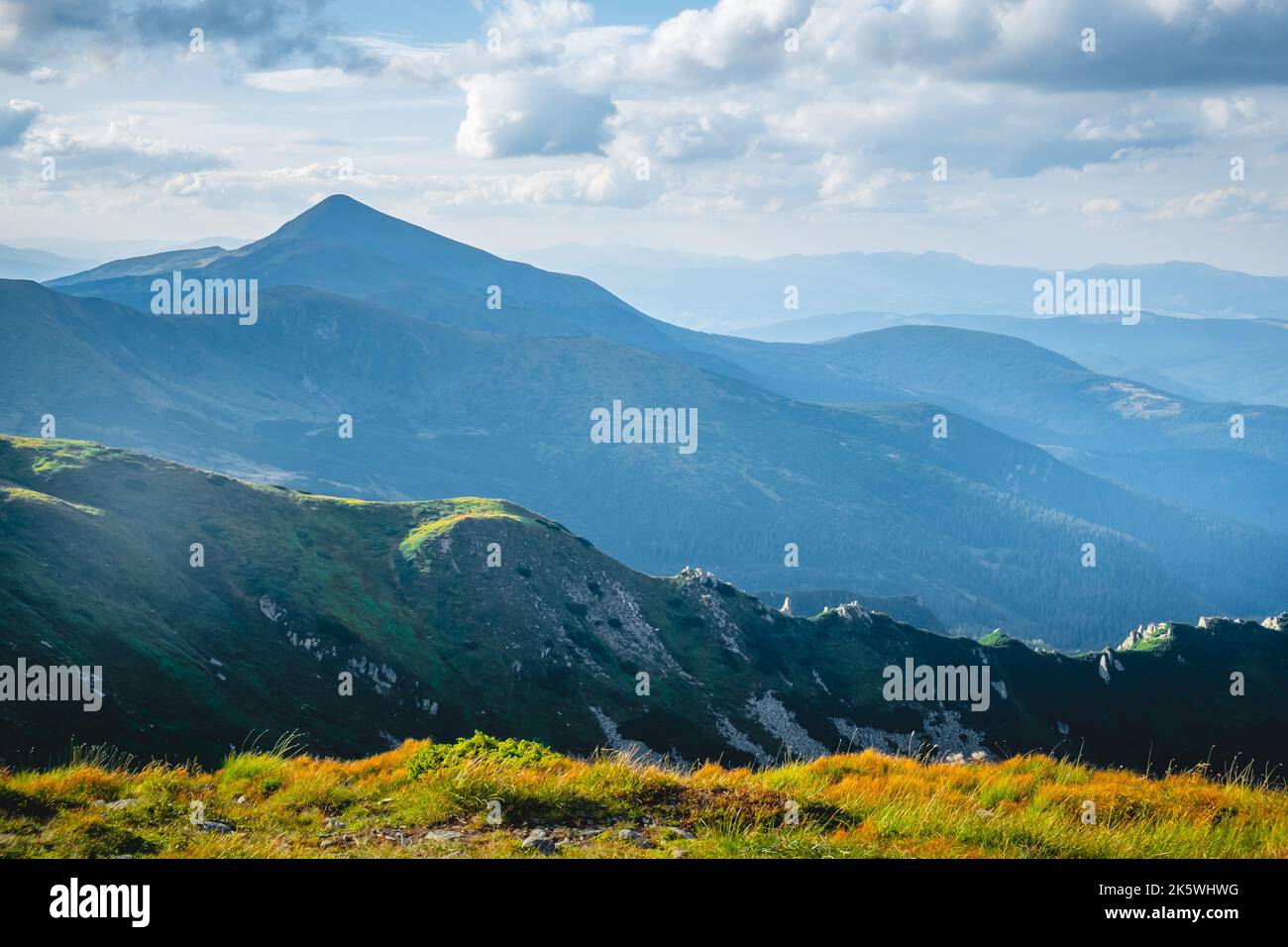 Amazing sunny mountain range landscape in alpine highlands. Green grass ...