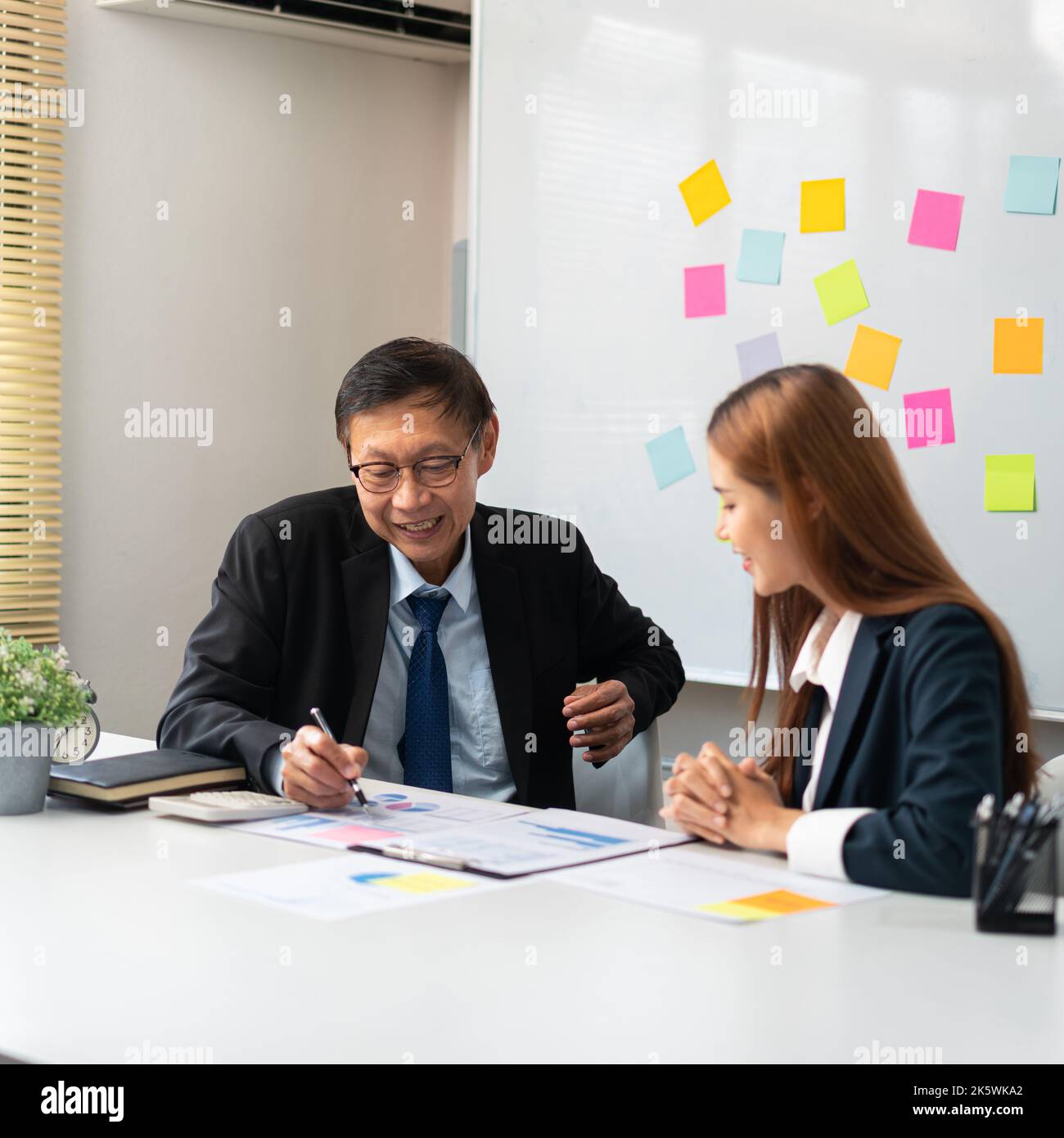 Business partnership concept, Senior in business point on document to ...