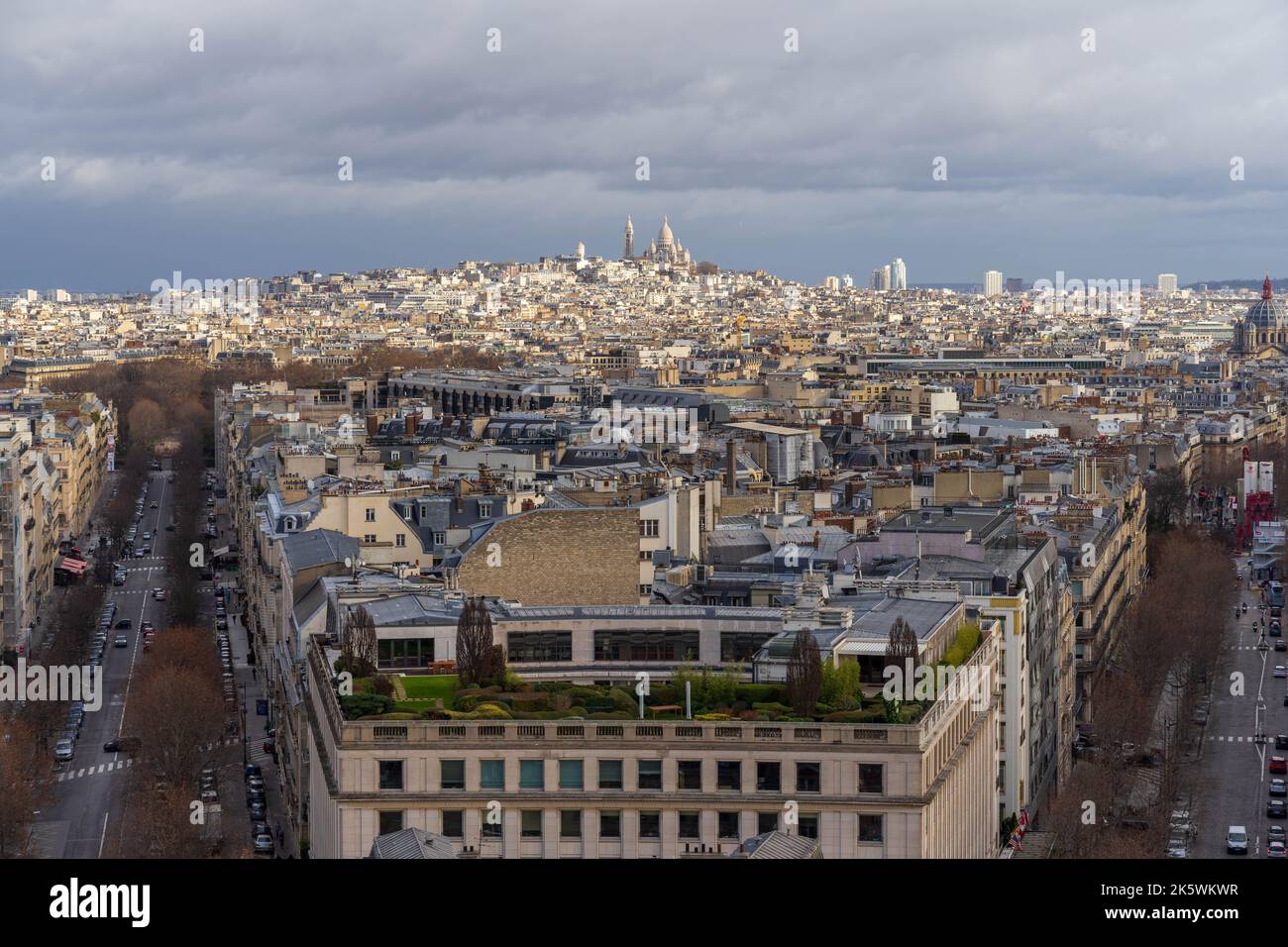 An aerial view of cityscape Paris surrounded by buildings under cloudy ...