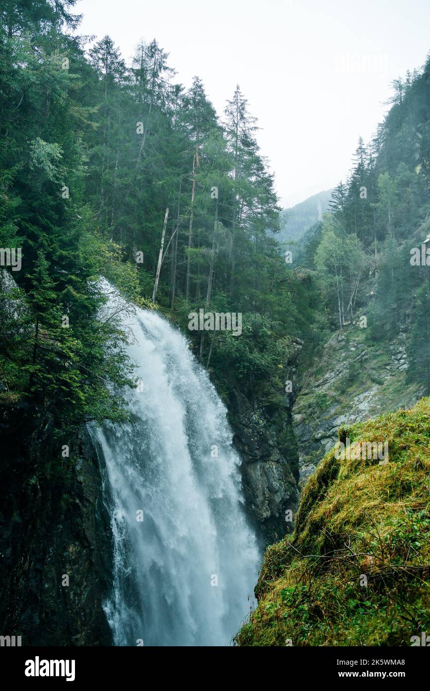 landscape photo of Riva waterfall at Dolomites with in yellow rain ...