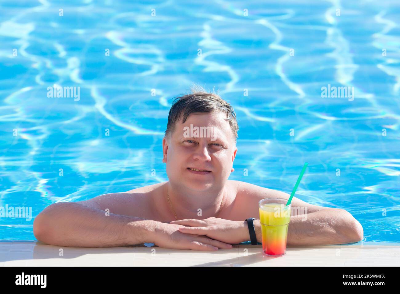 Man enjoying a cocktail while swimming in the pool Stock Photo - Alamy