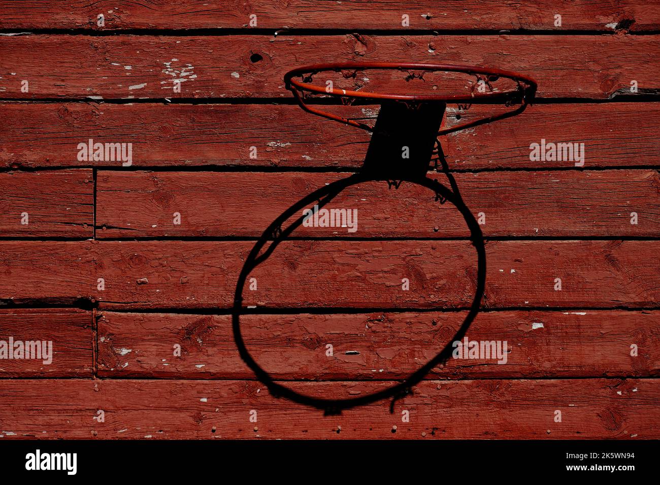 Worn basketball hoop nailed onto old red barn wall Stock Photo - Alamy