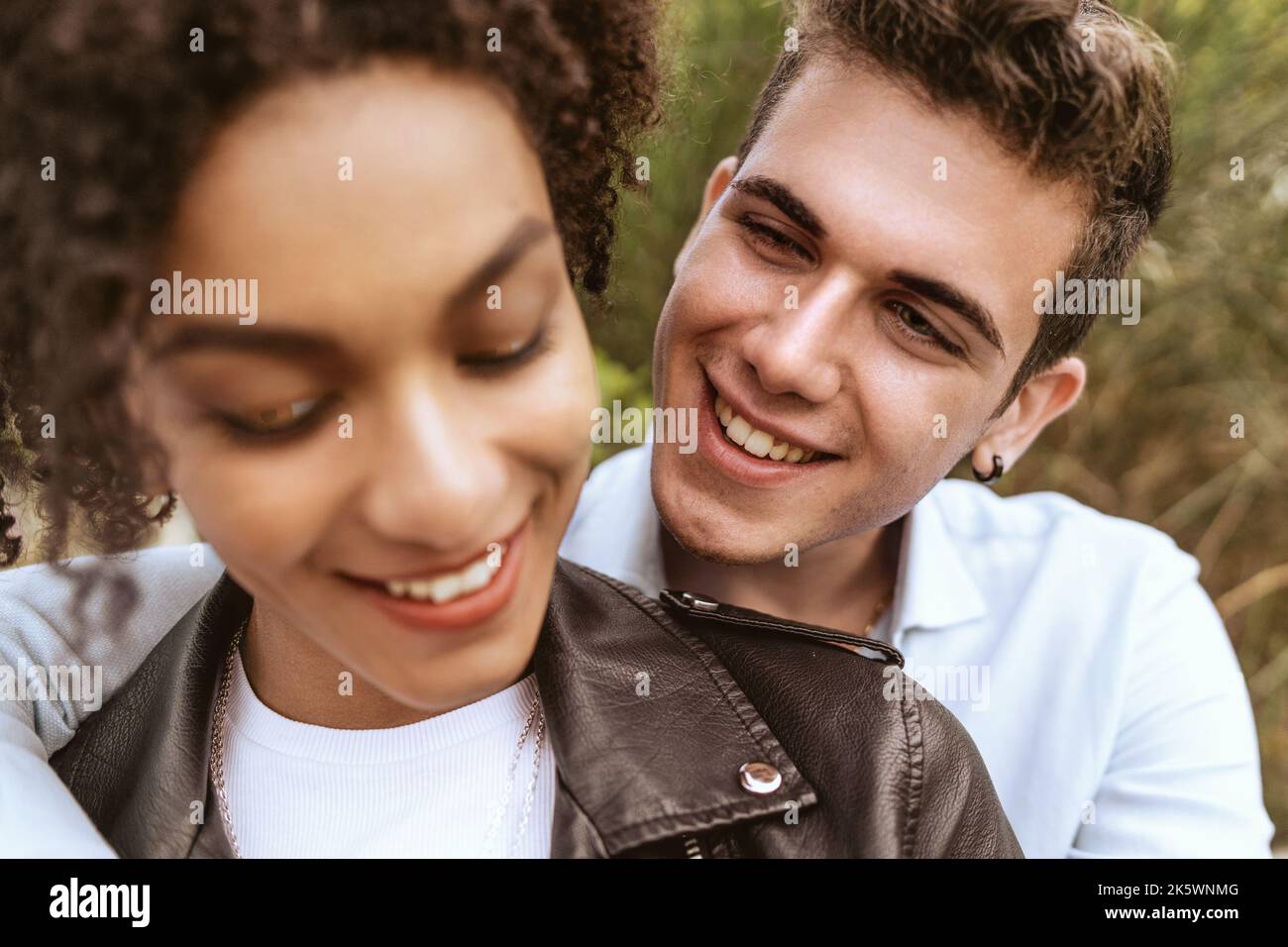 Portrait of romantic international young couple hug outdoors, loving smiling multiethnic ...