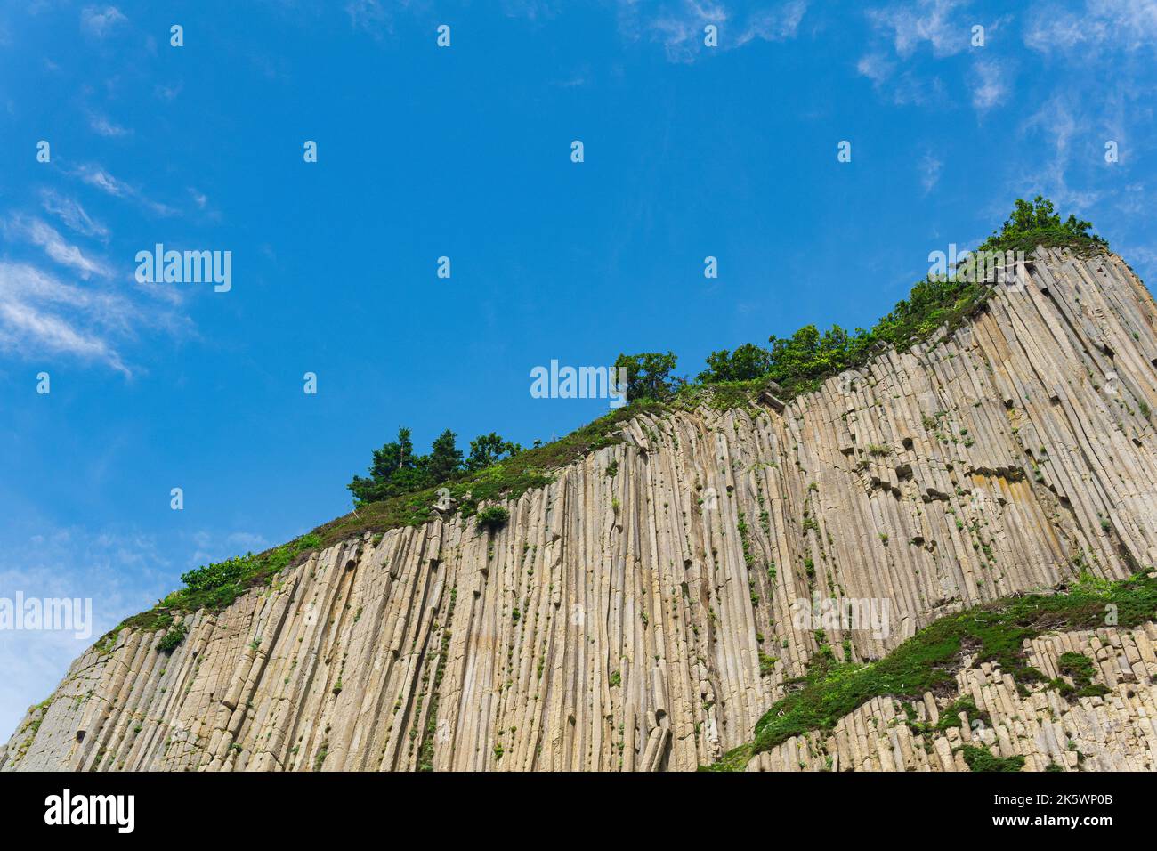top of columnar volcanic basalt cliff against the background of the sky ...