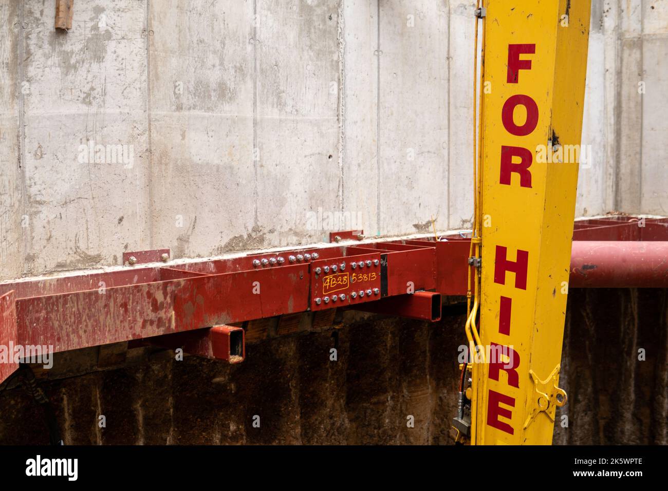 Construction site concrete wall and red steel beam with yellow ...