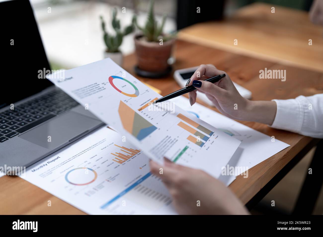 Businesswoman pen pointing turnover with graph chart report and use ...