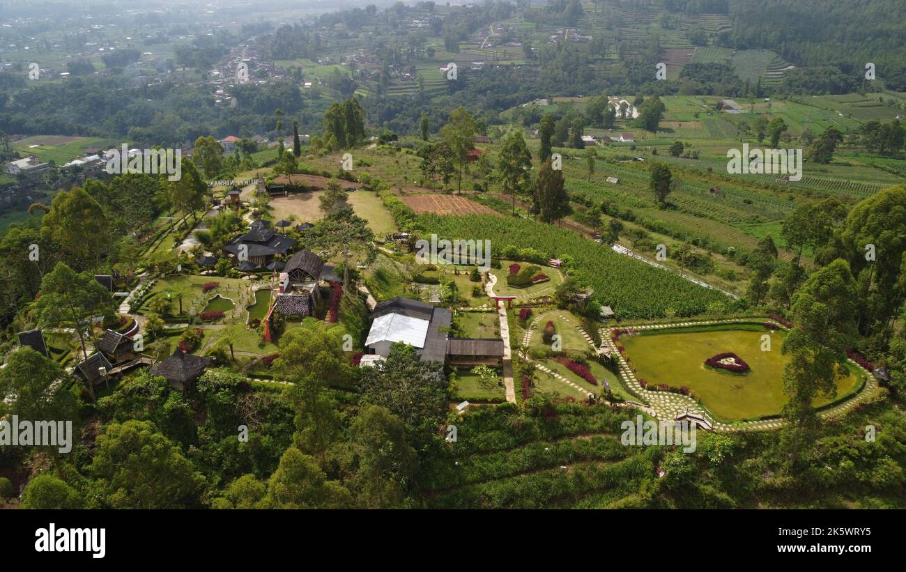 A high-angle shot of the green Java island and buildings in Indonesia ...
