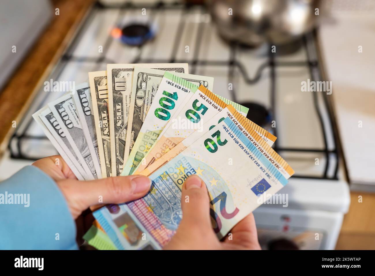 Euro and dollar banknotes on the background of a burning gas burner ...