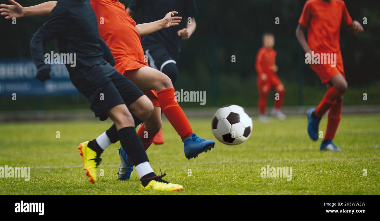 Competition between players running and kicking football ball. Young ...
