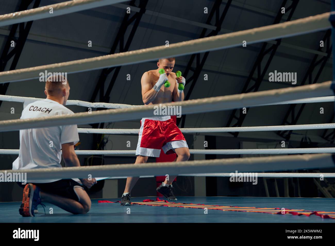 Proper warm up. Young male boxer training with personal coach, trainer ...