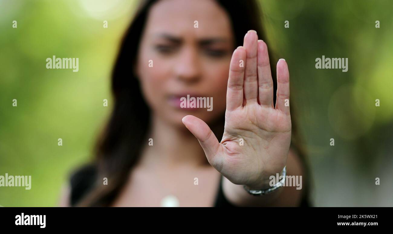 Woman annoyed making stop sign with hand, saying no, expressing defense ...