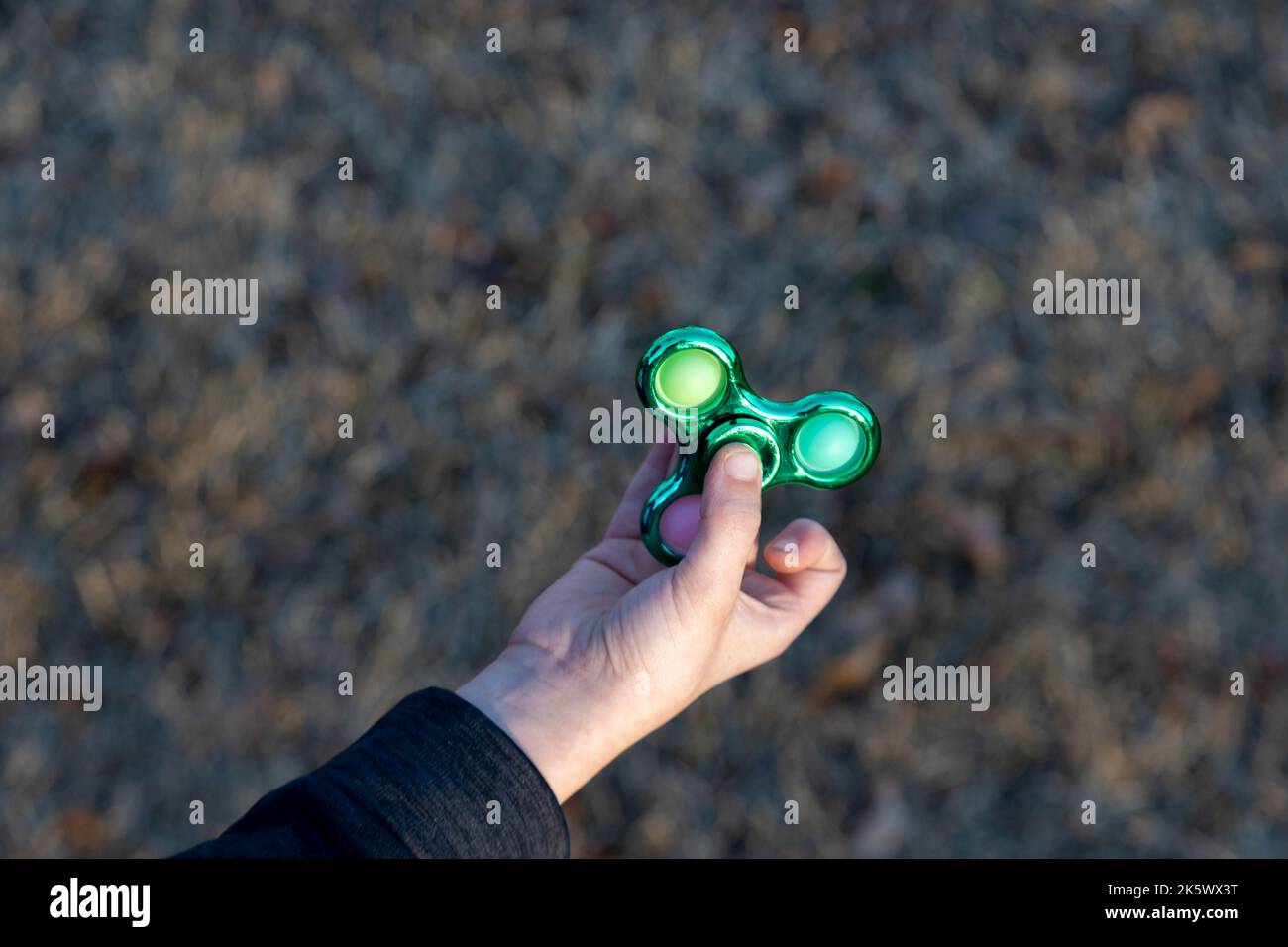 Child playing with a spinning fidget toy Stock Photo - Alamy