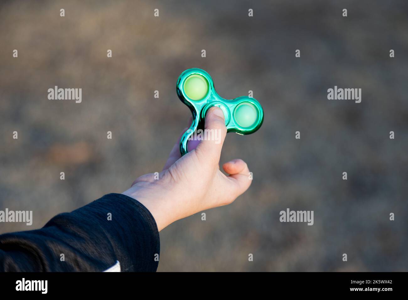 Child playing with a spinning fidget toy Stock Photo - Alamy