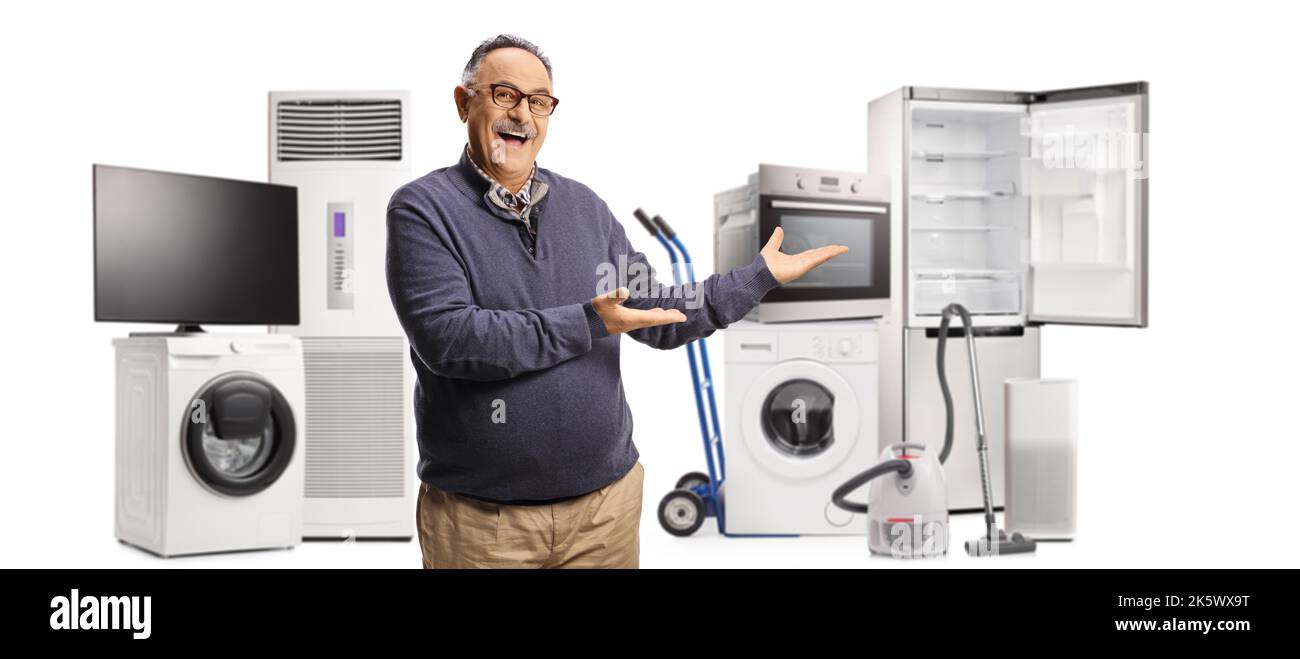 Cheerful mature man showing a group of electrical home appliances ...