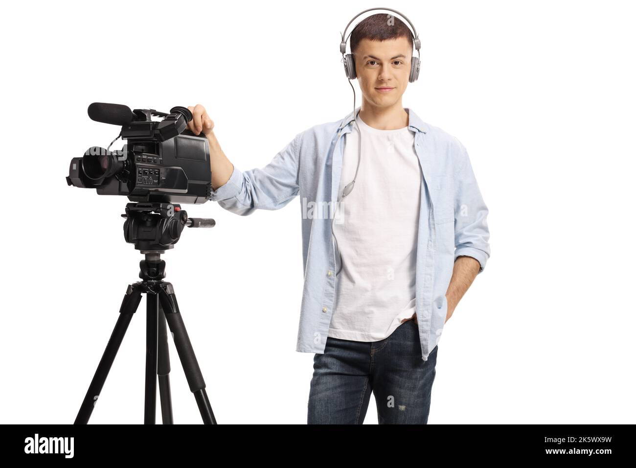 Young camera man posing with camera on a stand isolated on white ...