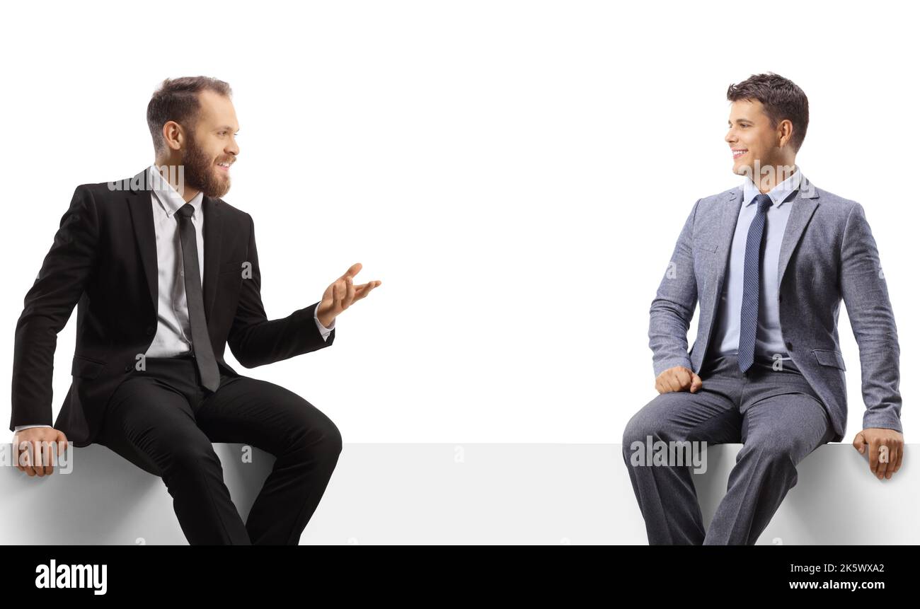 Two young professional men sitting on a panel and talking isolated on ...
