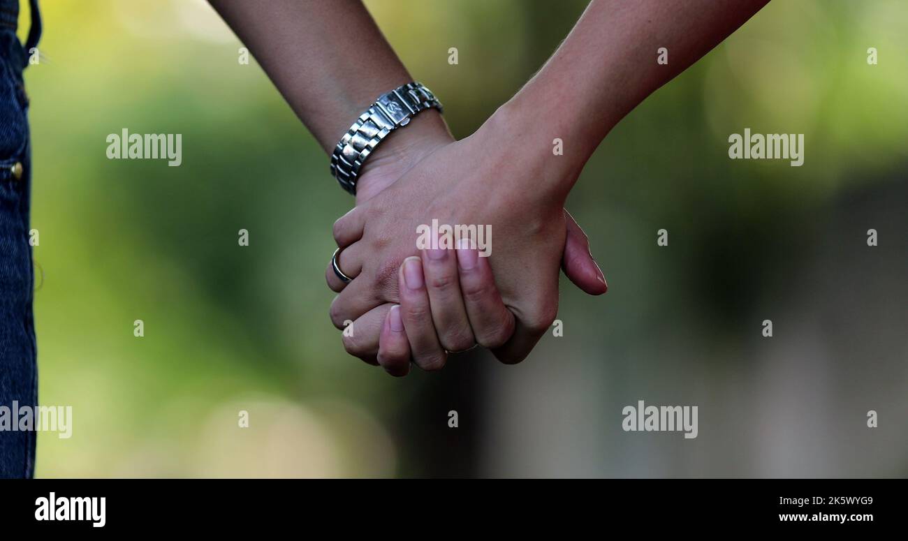 Two people holding hands outside, close-up hand holding Stock Photo - Alamy