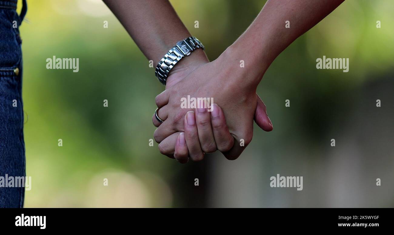 Two people holding hands outside, close-up hand holding Stock Photo - Alamy