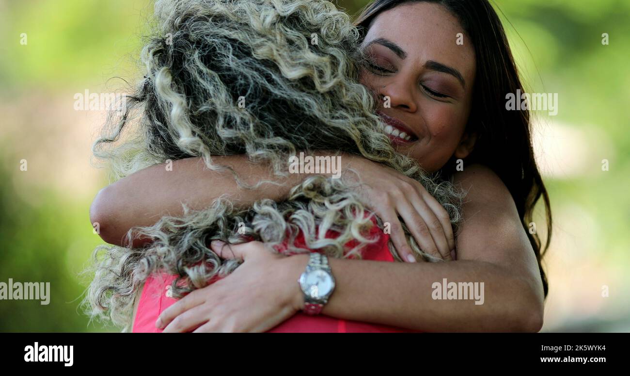 Two women friends embrace outside, people warm hug Stock Photo - Alamy